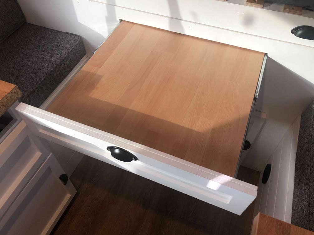 Aménager un fourgon en van avec une table en bois sur mesure